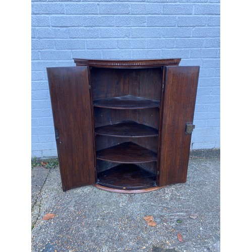 A 19th Century oak bow fronted corner cupboard