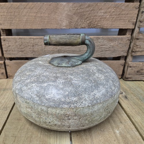 Antique granite curling stone fitted with brass and wood handle.