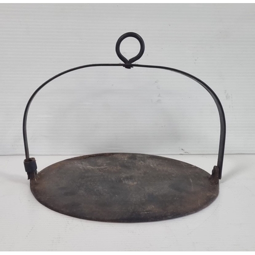 Iron hearth griddle with arched suspension handle and loop finial, H: 29cm