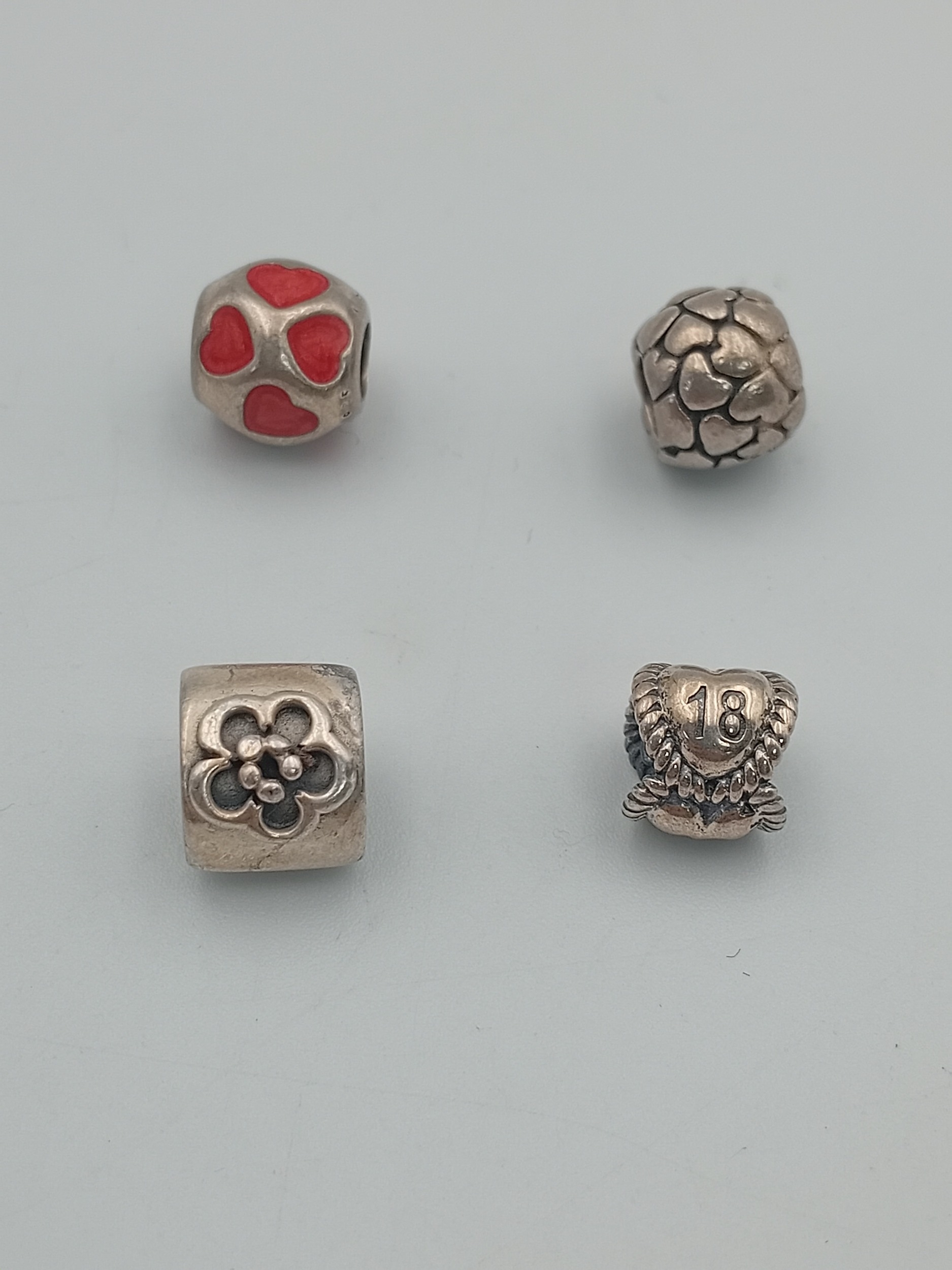 A Set of Four Pandora Sterling Silver Charms A set of four Pandora ...