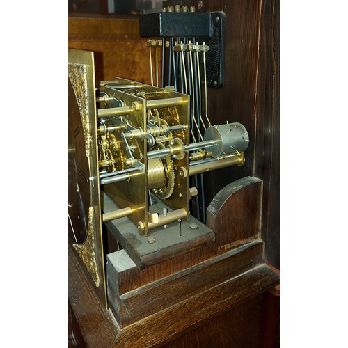 An early 20th Century oak longcase clock, the arched hood above a ...