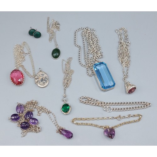 A collection of silver pendants with chains and other related silver ...