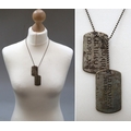 A pair of military-style metal identity tags, each suspended on a ball ...