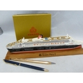 Cunard - a metal model of the Queen Mary 2, on wooden plinth; a ball ...