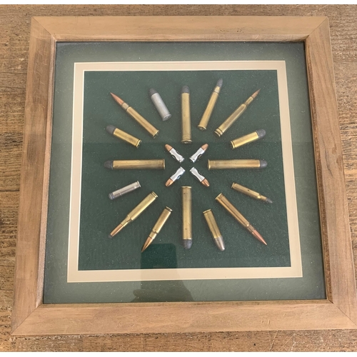 A glazed case display of various inert bullets for handguns and rifles ...