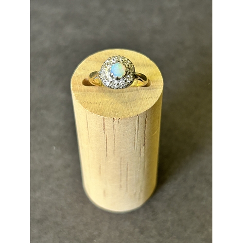 An 18ct gold ring set with an opal (some surface scuffs) set with very ...