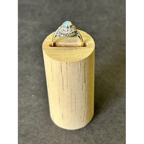 An 18ct gold ring set with an opal (some surface scuffs) set with very ...