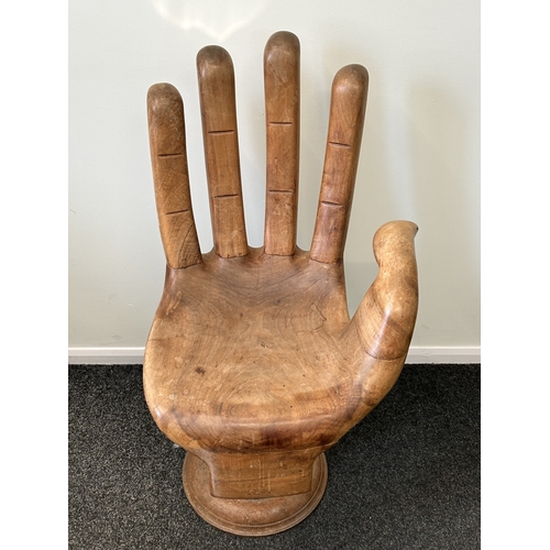A large wooden hand shaped swivel chair, approx. 40" high x 20" wide ...