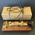 A boxed 'Kent' straight morse key of brass construction with cables ...