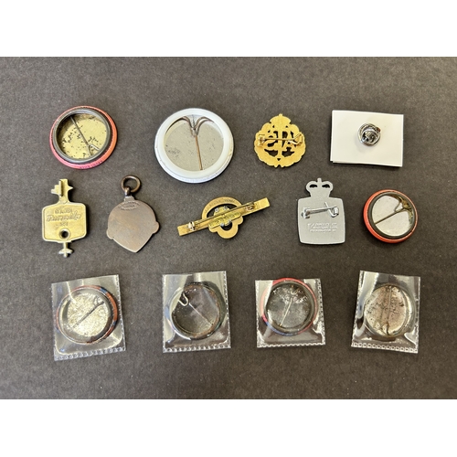 A selection of vintage badges including military and Elvis