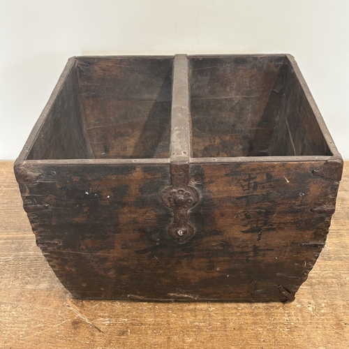 An antique Oriental solid wood basket with metal strap fittings, 13" x ...