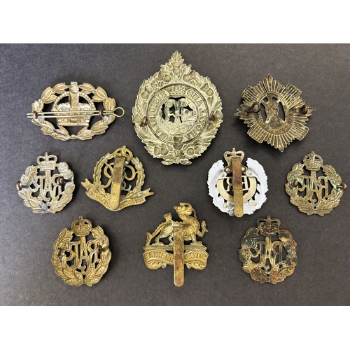 A small group of vintage military cap badges