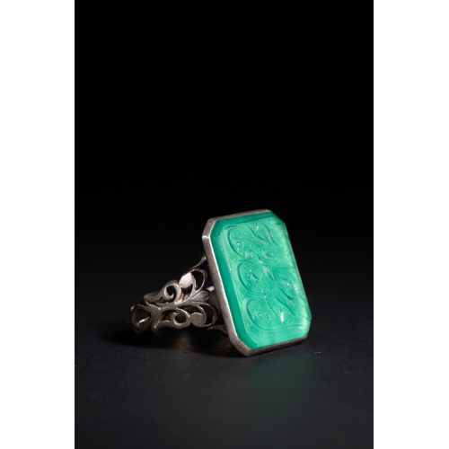 An Islamic Silver Ring with Inscribed Green Agate. The ring features a ...