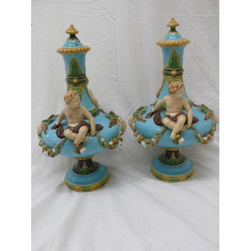 Pair of Minton Majolica urns with covers and decoration of putti seated ...