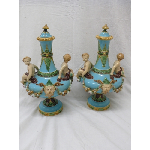 Pair of Minton Majolica urns with covers and decoration of putti seated ...
