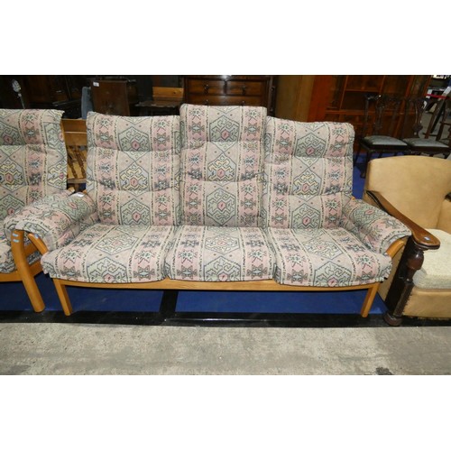 A 1980s vintage blonde wood Ercol three-seater settee with patterned ...