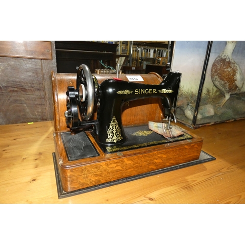 A vintage singer hand sewing machine in a wooden carry case