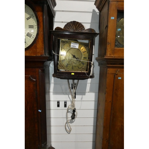 An oak case wall clock with a decorative brass face and 30-hour movement