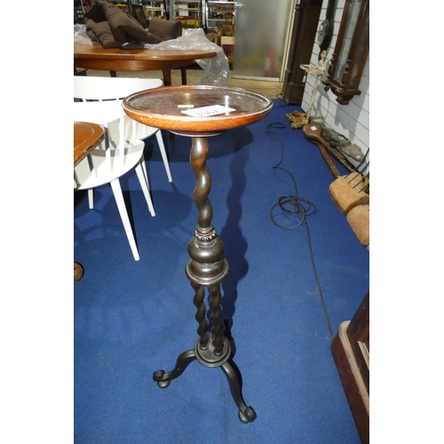 A small Edwardian dark wood pedestal torchere on three feet