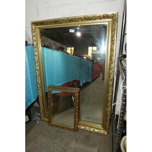 A rectangular beveled wall mirror in a decorative gilt frame and a small gilt framed rectangular wal