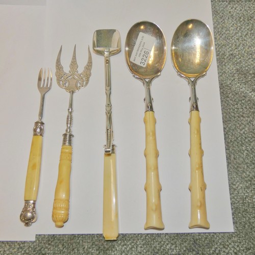 A pair of engraved silver spoons with decorative bone handles, two ...