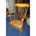 A rail back country style rocking chair with a wooden seat