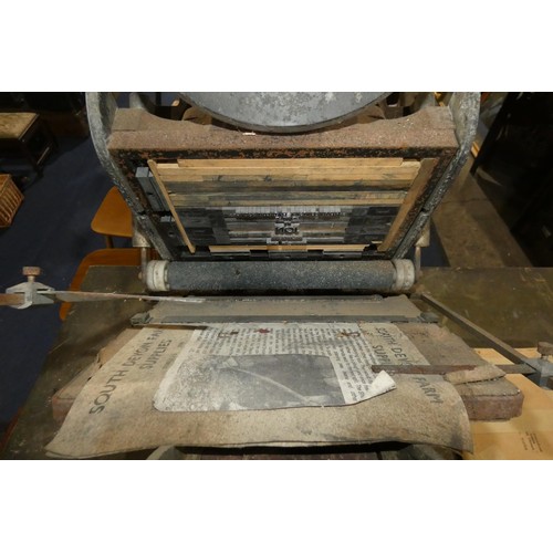 A vintage Adana printing press and a wooden multi drawer printing cabinet