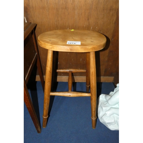 A vintage lightwood oval-topped kitchen stool