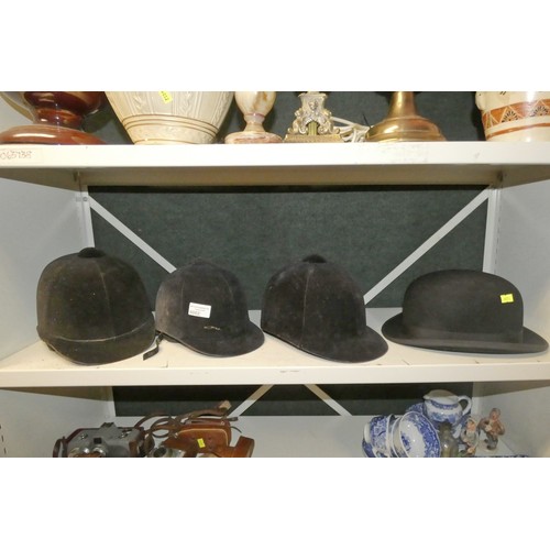 A vintage bowler hat and three vintage riding hats