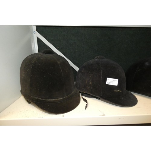 A vintage bowler hat and three vintage riding hats