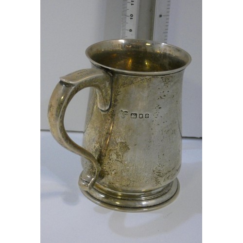 A small silver christening tankered, approximately 10 centimeters tall ...