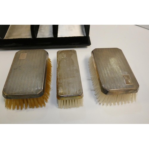 A vintage boxed set of three hair brushes each with a silverback