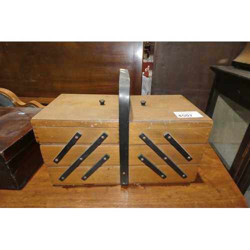 A vintage telescopic folding sewing box containing sewing accessories