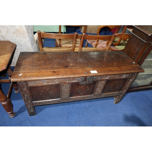 An early caeved oak coffer with a lift lid and panelleled front ...