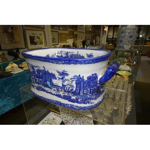 A large blue and white pictorial patterned ceramic foot bath with two ...