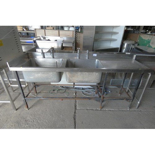 A commercial stainless steel double sink unit approx 240x60cm