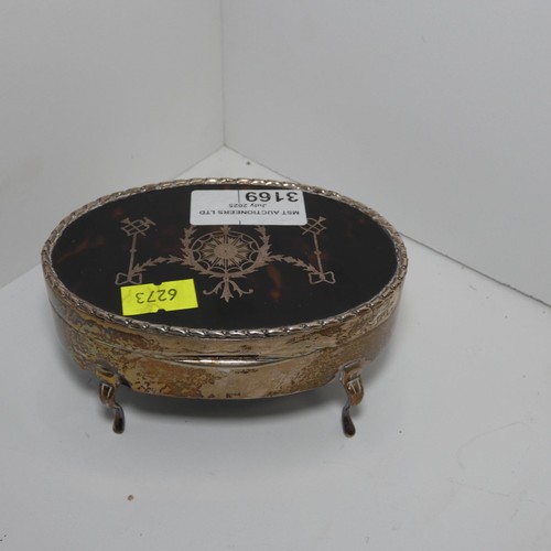 A small silver and tortoise shell decorative trinket box with a lift ...