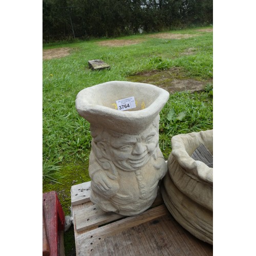 A concrete toby jug style planter