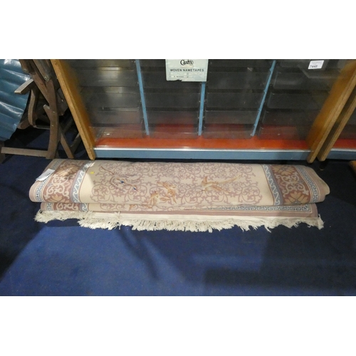 A fawn ground floral patterned Chinese carpet, approximately 280 cm X ...