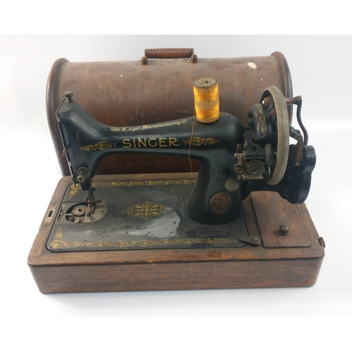 A vintage hand-operated SINGER SEWING MACHINE in a wooden case with the ...