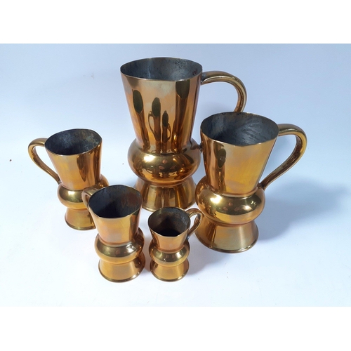 VINTAGE - A set of copper-bottomed brass spirit measuring jugs ...