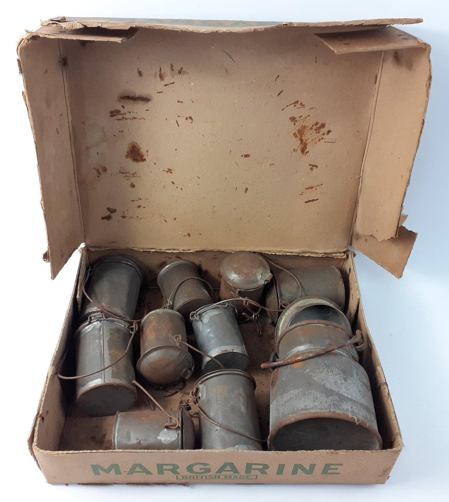 An old Stork margarine box filled with small lidded and hinged tin pots ...