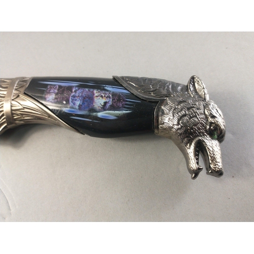A modern decorative knife in hard sheath with Wolf Head finial. The ...