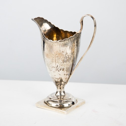 GEORGE III ENGRAVED SILVER CREAM JUG, helmet shaped with square foot ...