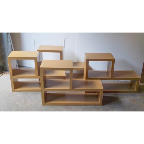 A RANGE OF WOOD-EFFECT LOW, OPEN SHELVING IN FOUR SECTIONS, EACH ...