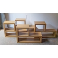 A RANGE OF WOOD-EFFECT LOW, OPEN SHELVING IN FOUR SECTIONS, EACH ...