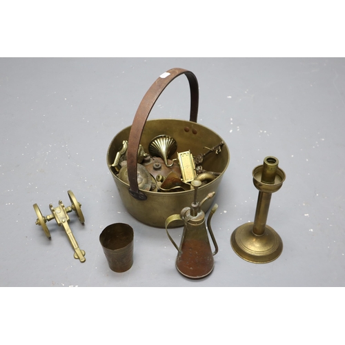 A large brass and steel cooking port with assorted brass items inside ...