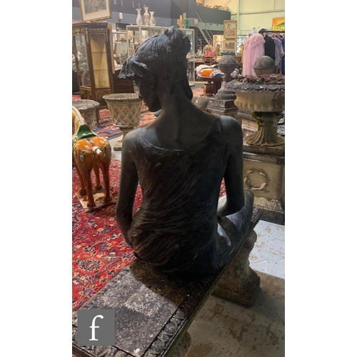 A life size cast metal figure of a female, cast in seated position and ...