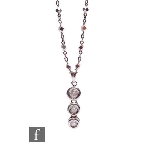 A 900 platinum graduated three stone diamond pendant, collar set stones ...