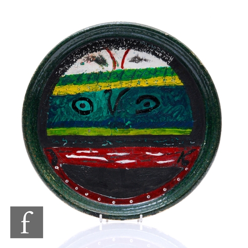A studio pottery charger, circa 1970s, decorated with an abstract face ...